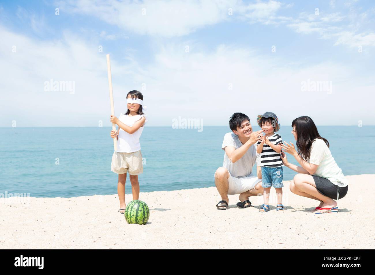 Family splitting watermelon on the beach Stock Photo - Alamy