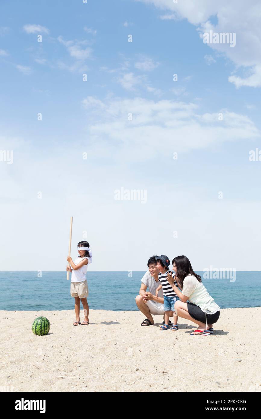 A family splitting watermelons on the beach Stock Photo - Alamy