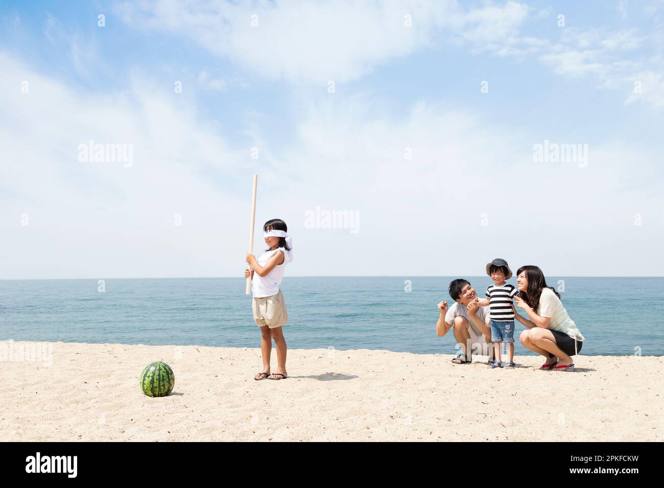 A family splitting watermelons on the beach Stock Photo - Alamy