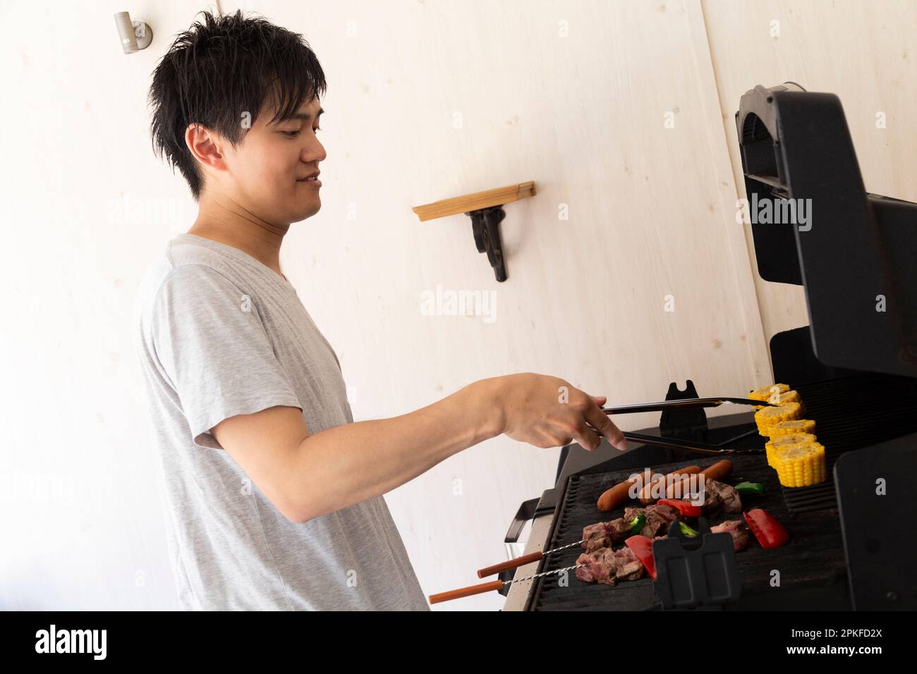 Man grilling meat on the grill Stock Photo - Alamy
