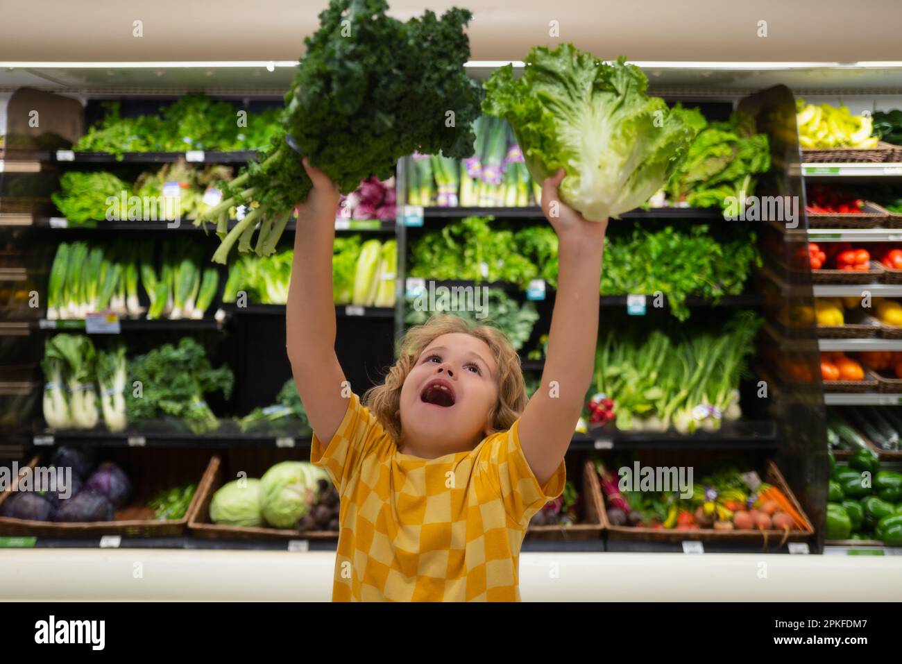 Child with lettuce chard vegetables. Child at vegetable supermarket ...