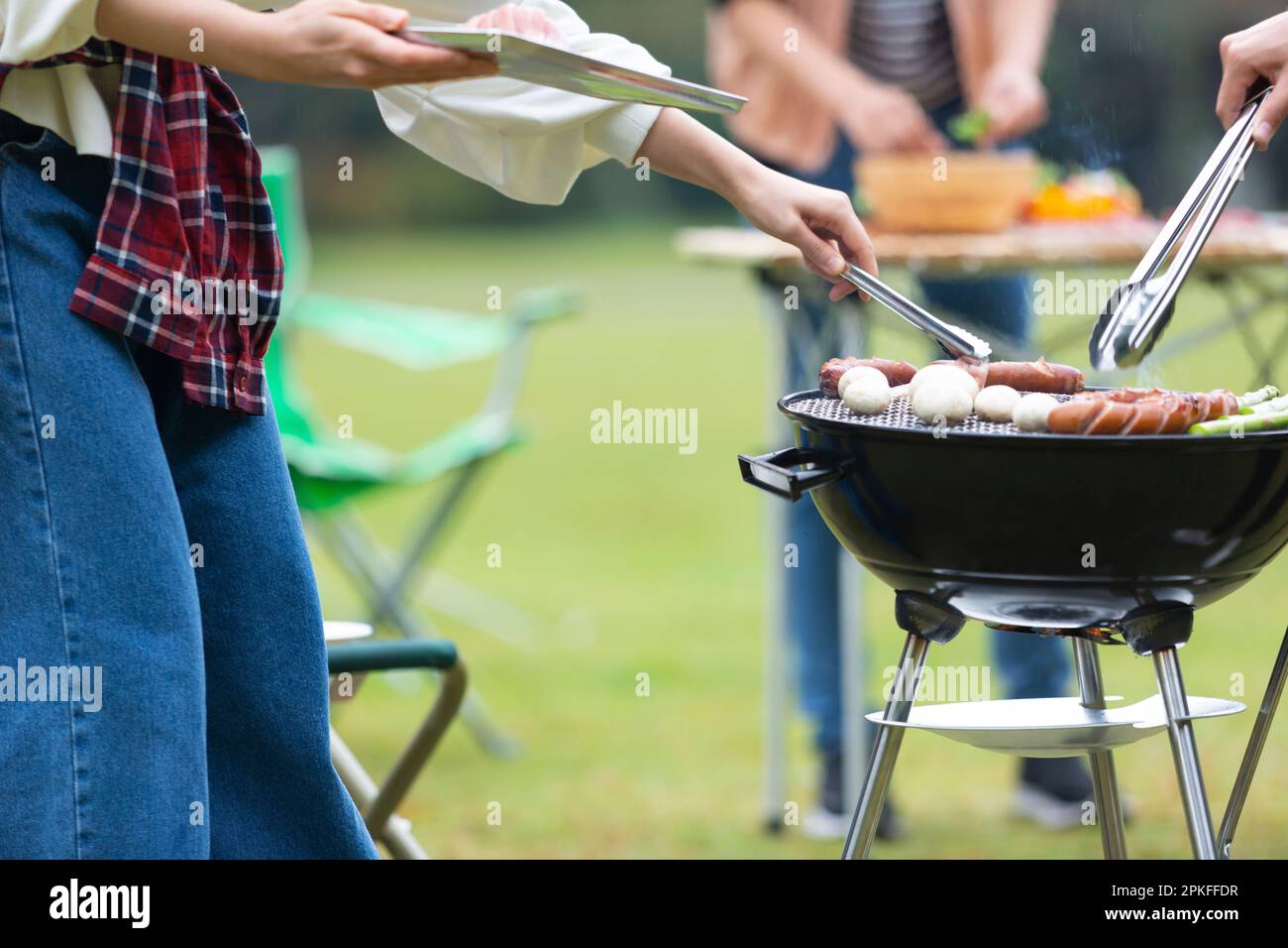 Woman's hand at barbecue Stock Photo - Alamy