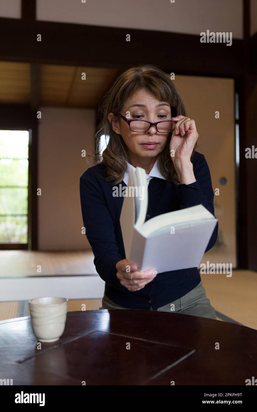 Elderly asian woman reading book hi-res stock photography and images ...