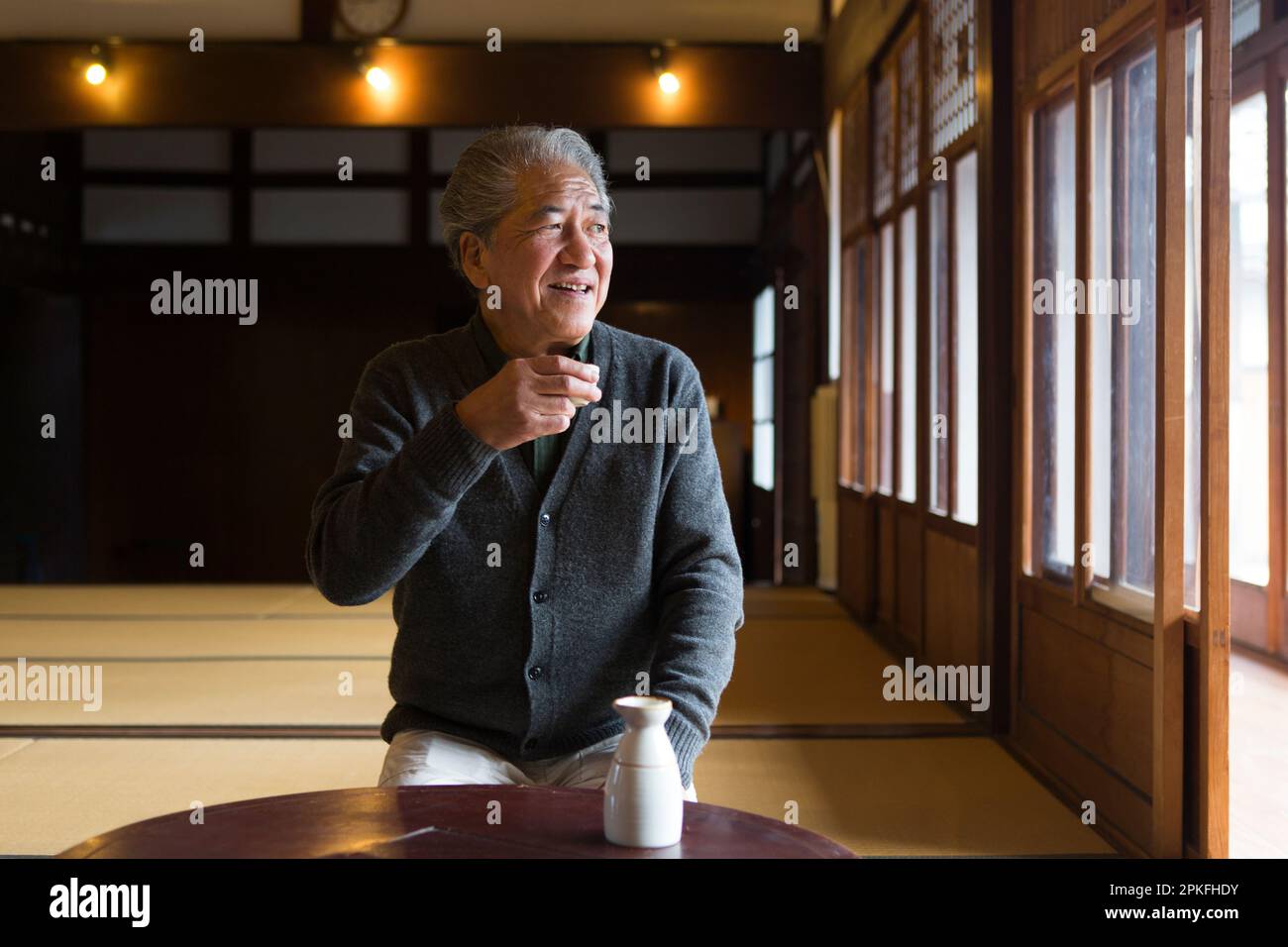 Senior man drinking sake at an old private house Stock Photo - Alamy