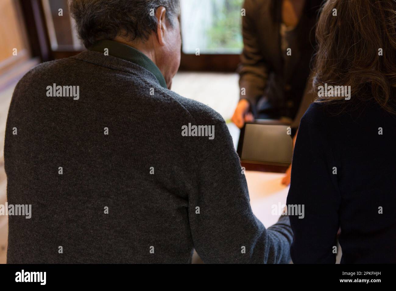 Senior couple listening to visitor's description in country house Stock ...