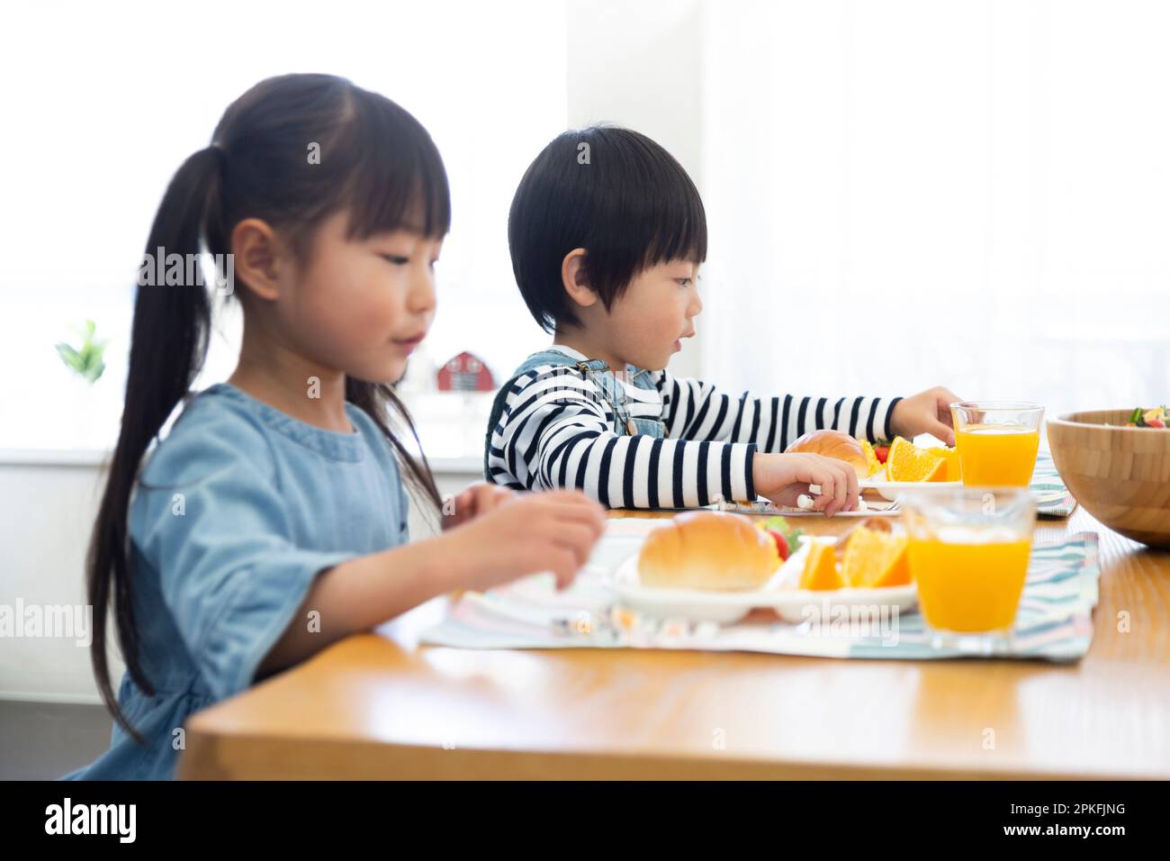 Siblings eating breakfast Stock Photo - Alamy