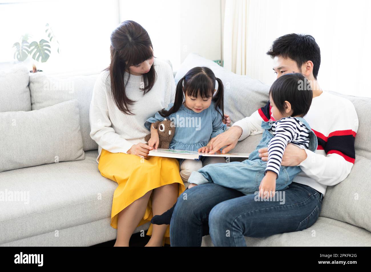 Family reading picture book Stock Photo - Alamy