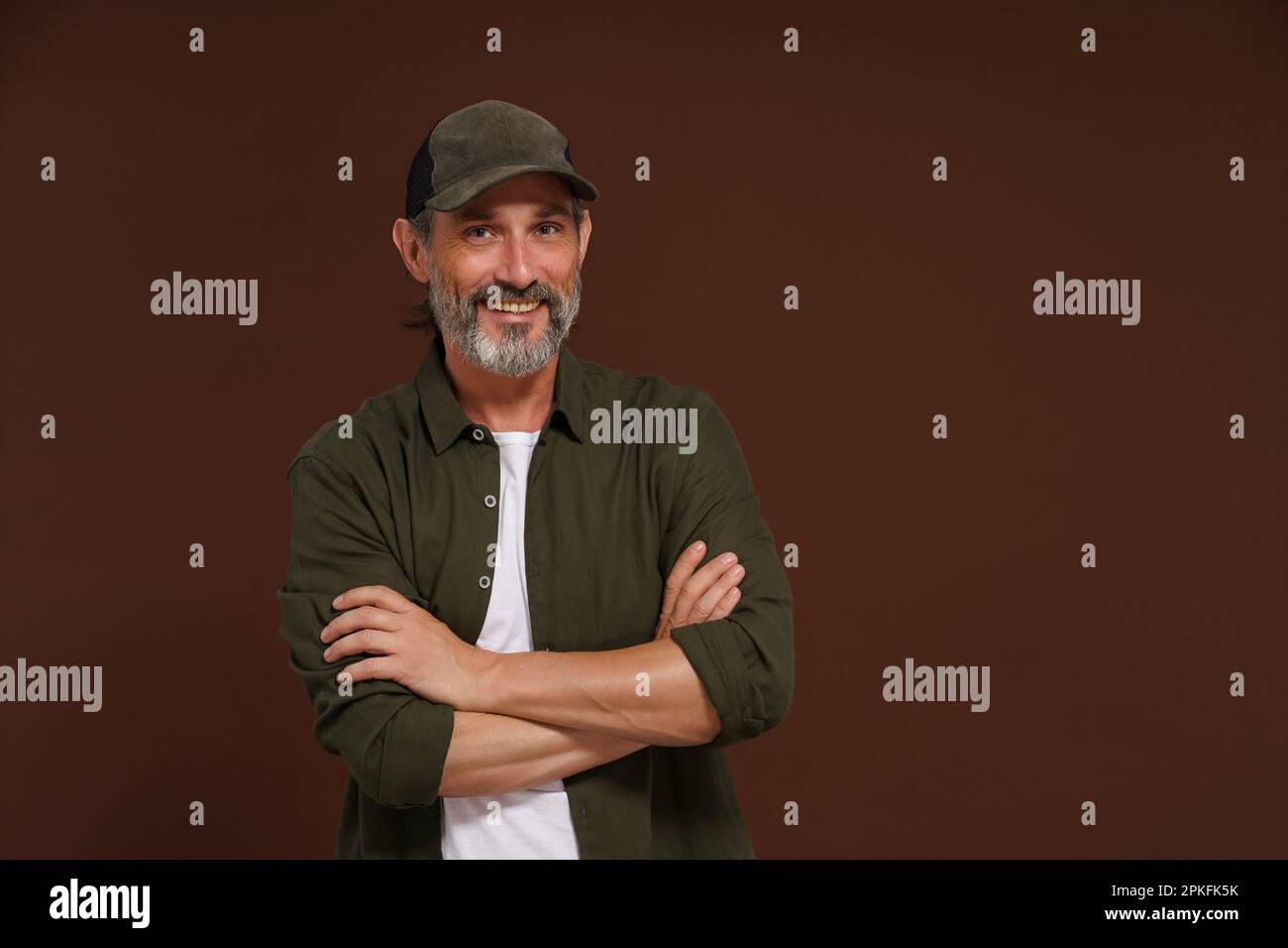 Happy Smiling man. A fisherman in a baseball cap and green shirt stands ...