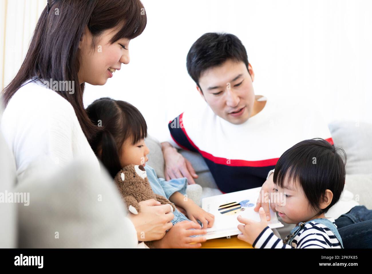 The family reading a picture book Stock Photo - Alamy