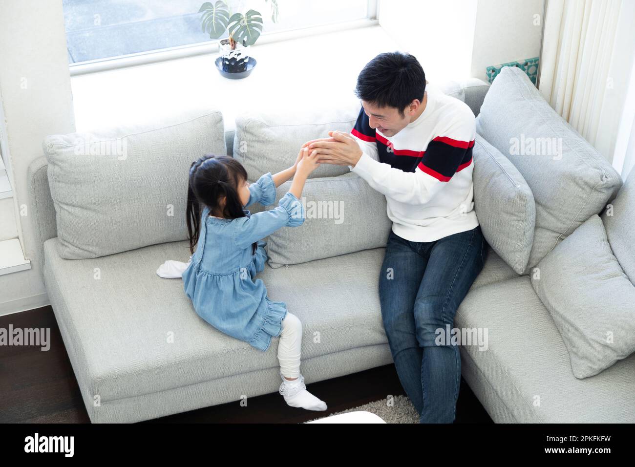 Parent and child playing on sofa Stock Photo - Alamy