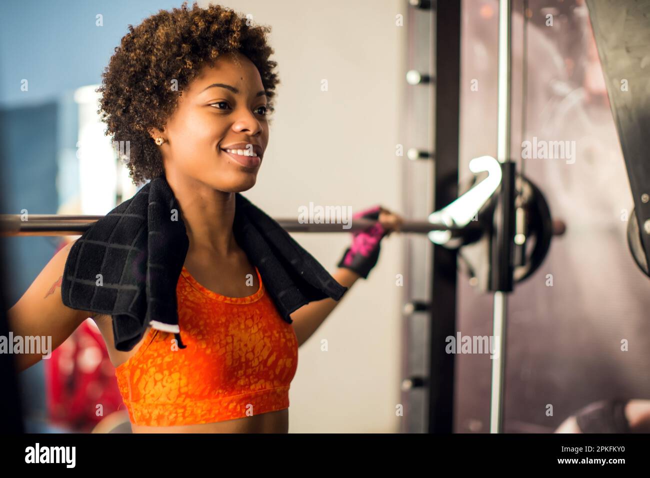 Fitness woman doing the barbell back squat using the power rack in a ...