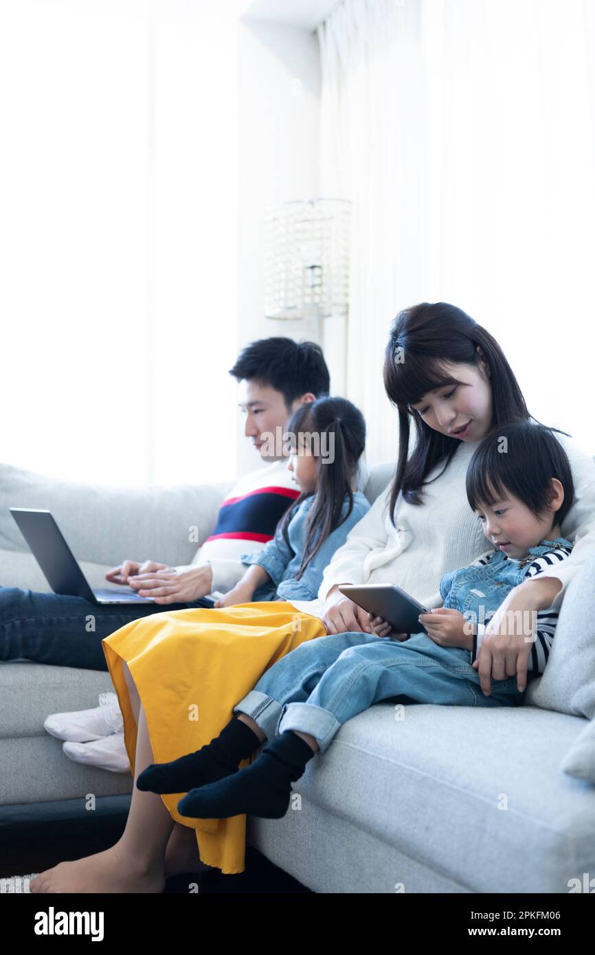 Family members watching PCs and tablets Stock Photo - Alamy