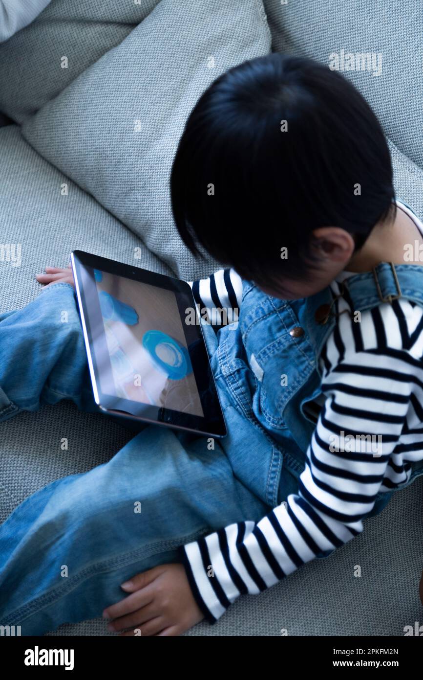 Boy engrossed in tablet Stock Photo - Alamy