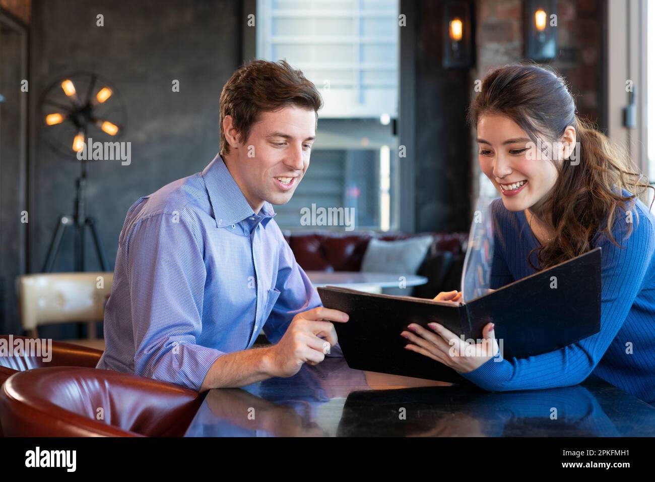 Couple looking at menu at cafe Stock Photo - Alamy