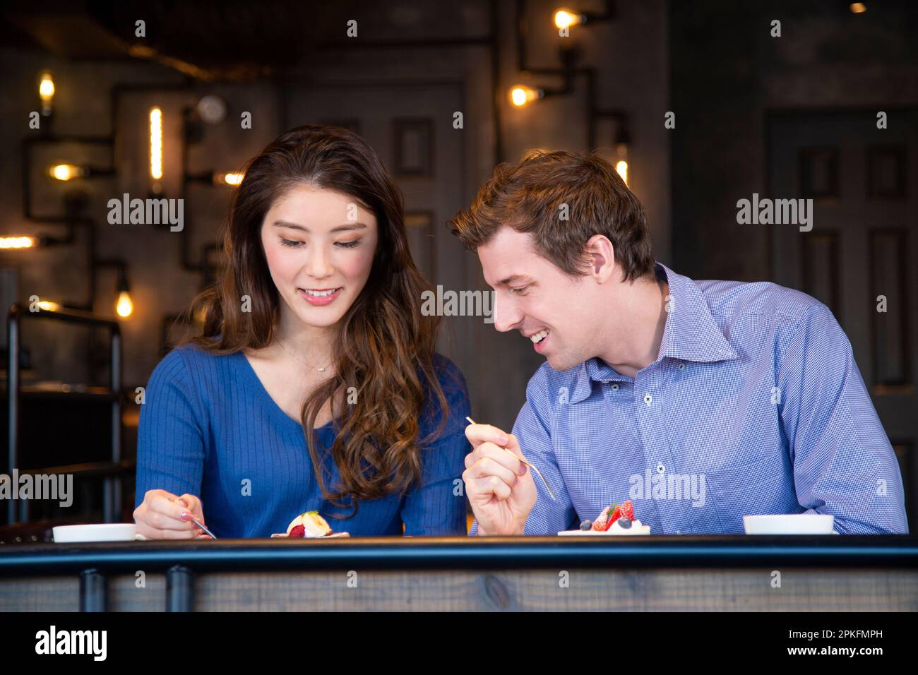 Couple eating cake at cafe Stock Photo - Alamy
