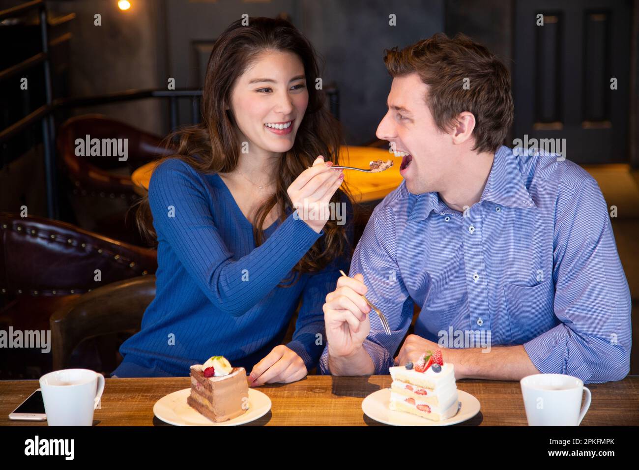 Couple feeding each other Stock Photo - Alamy