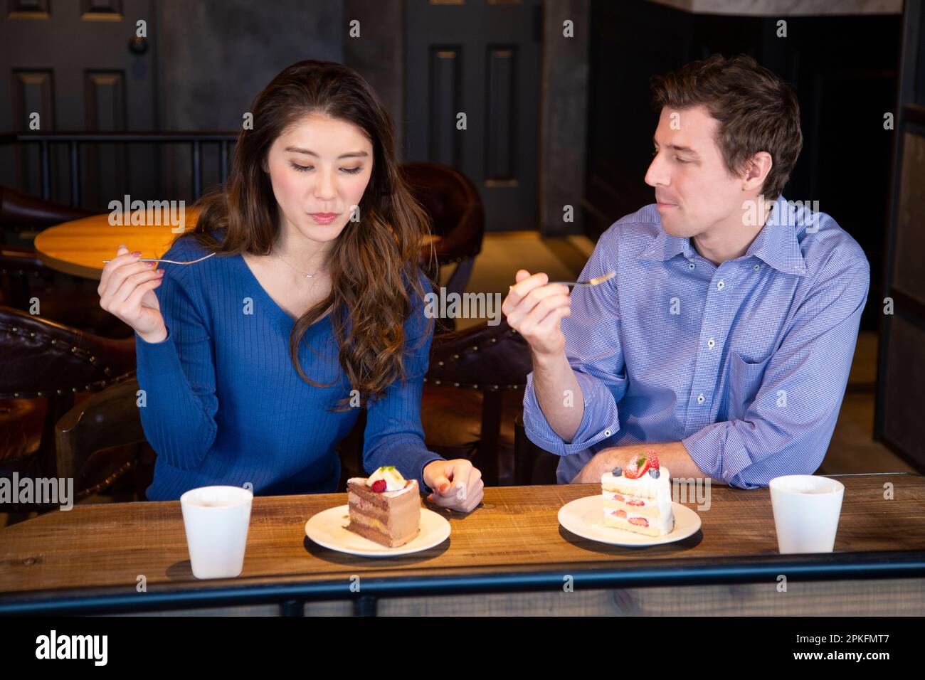 A couple eating cake at a cafe Stock Photo - Alamy