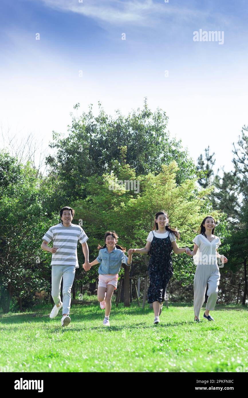 Family running hand in hand Stock Photo - Alamy