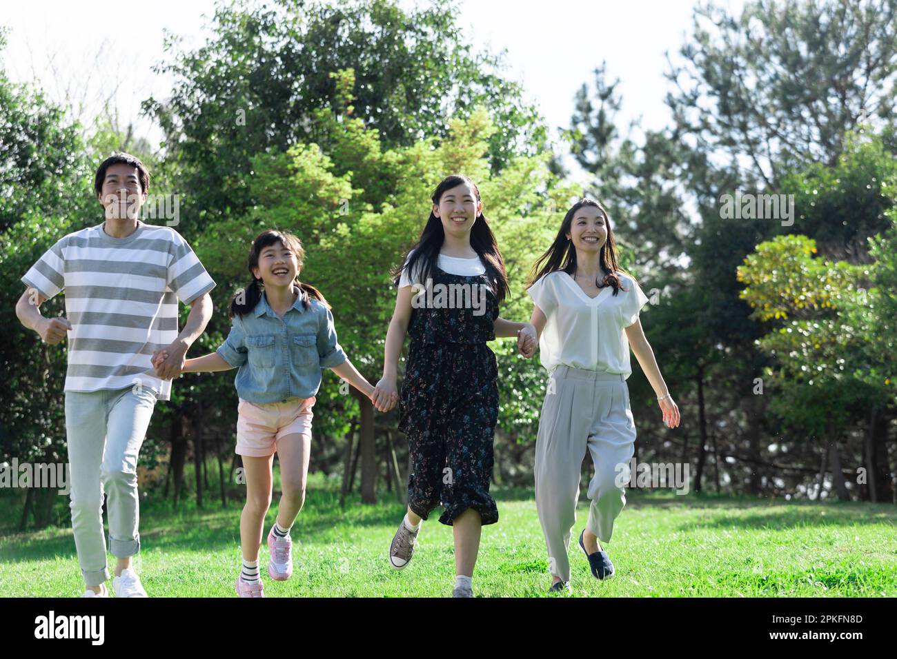 Family running hand in hand Stock Photo - Alamy