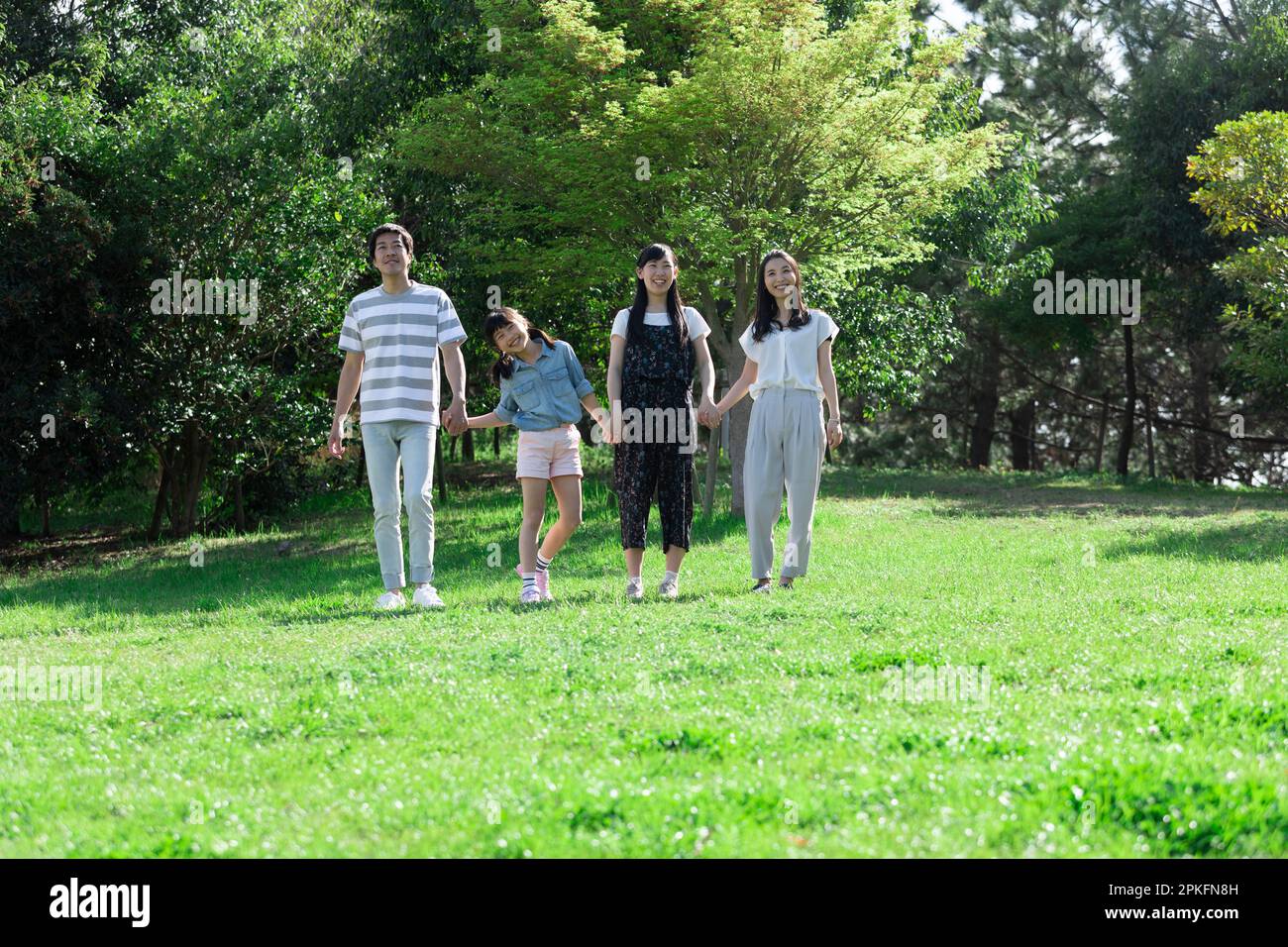 Family standing hand in hand Stock Photo - Alamy
