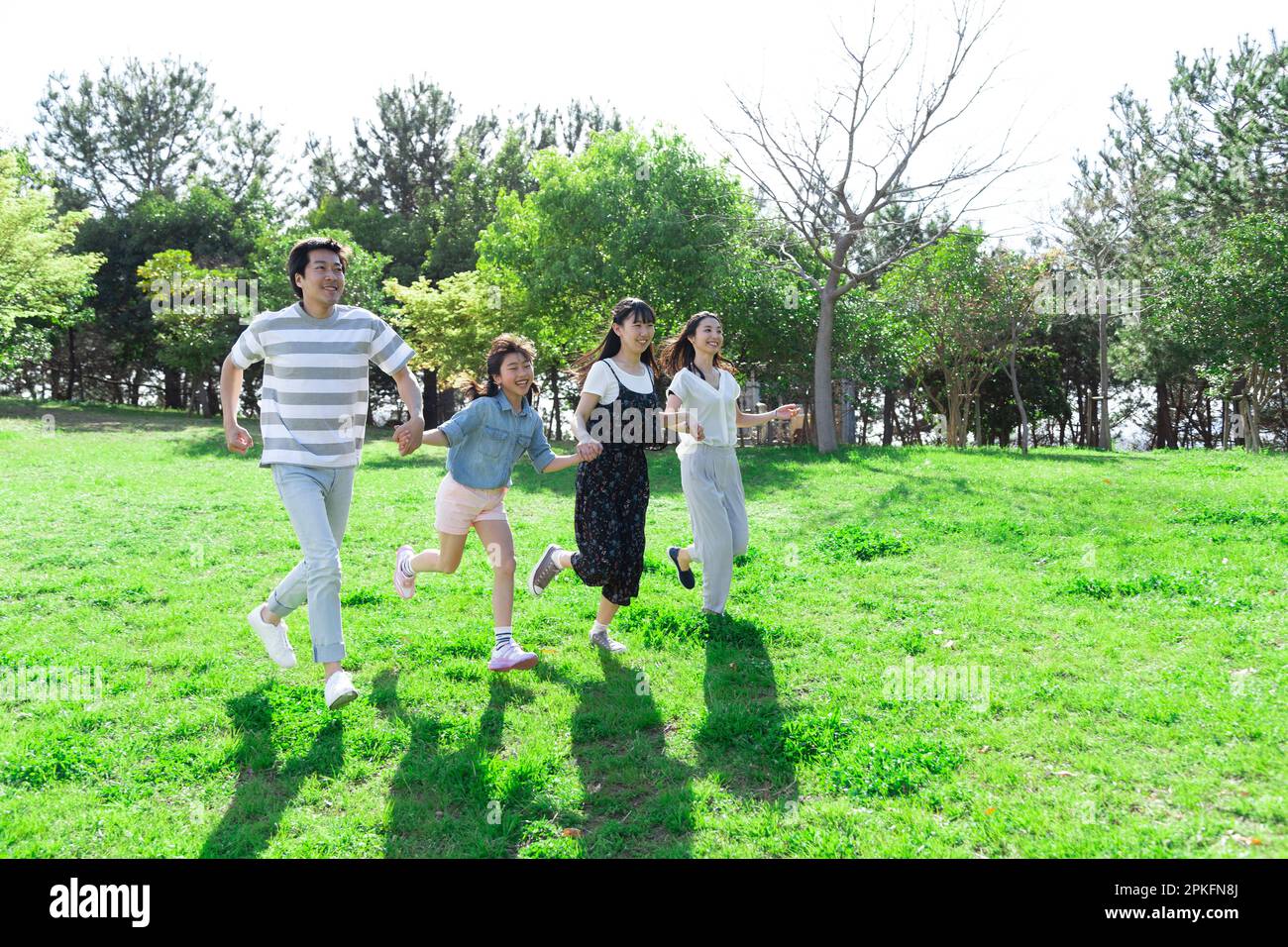 Family running hand in hand Stock Photo - Alamy