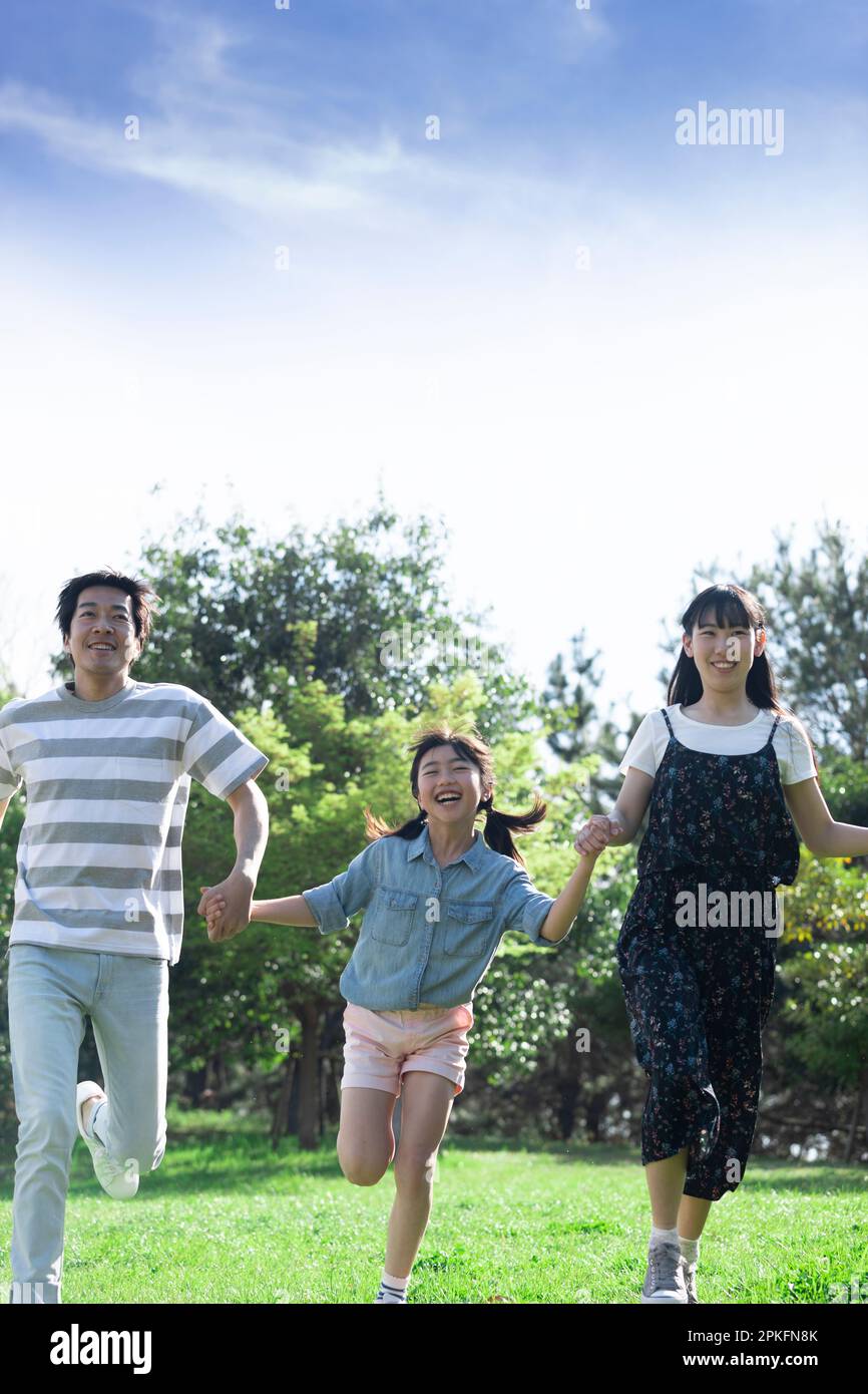 Family running hand in hand Stock Photo - Alamy