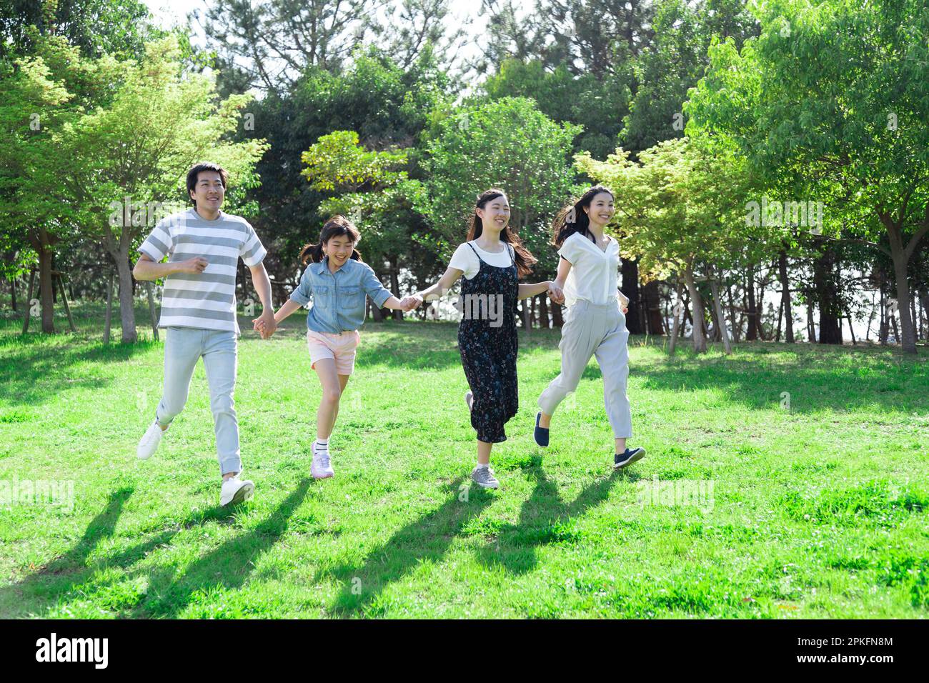 Family running hand in hand Stock Photo - Alamy