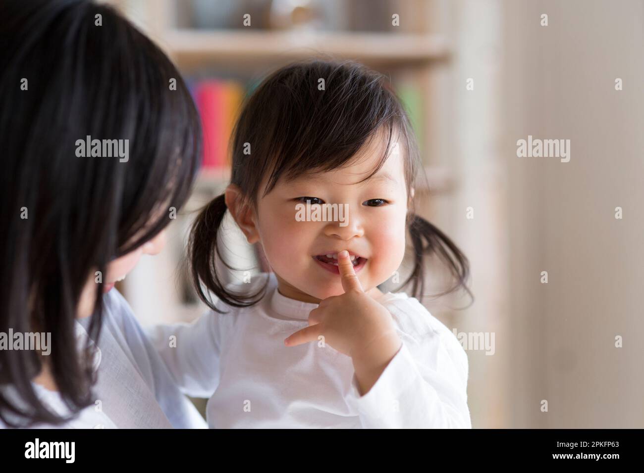 Child being held by mother Stock Photo - Alamy
