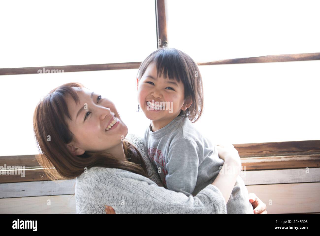 Mother hugging her daughter with a smile Stock Photo - Alamy