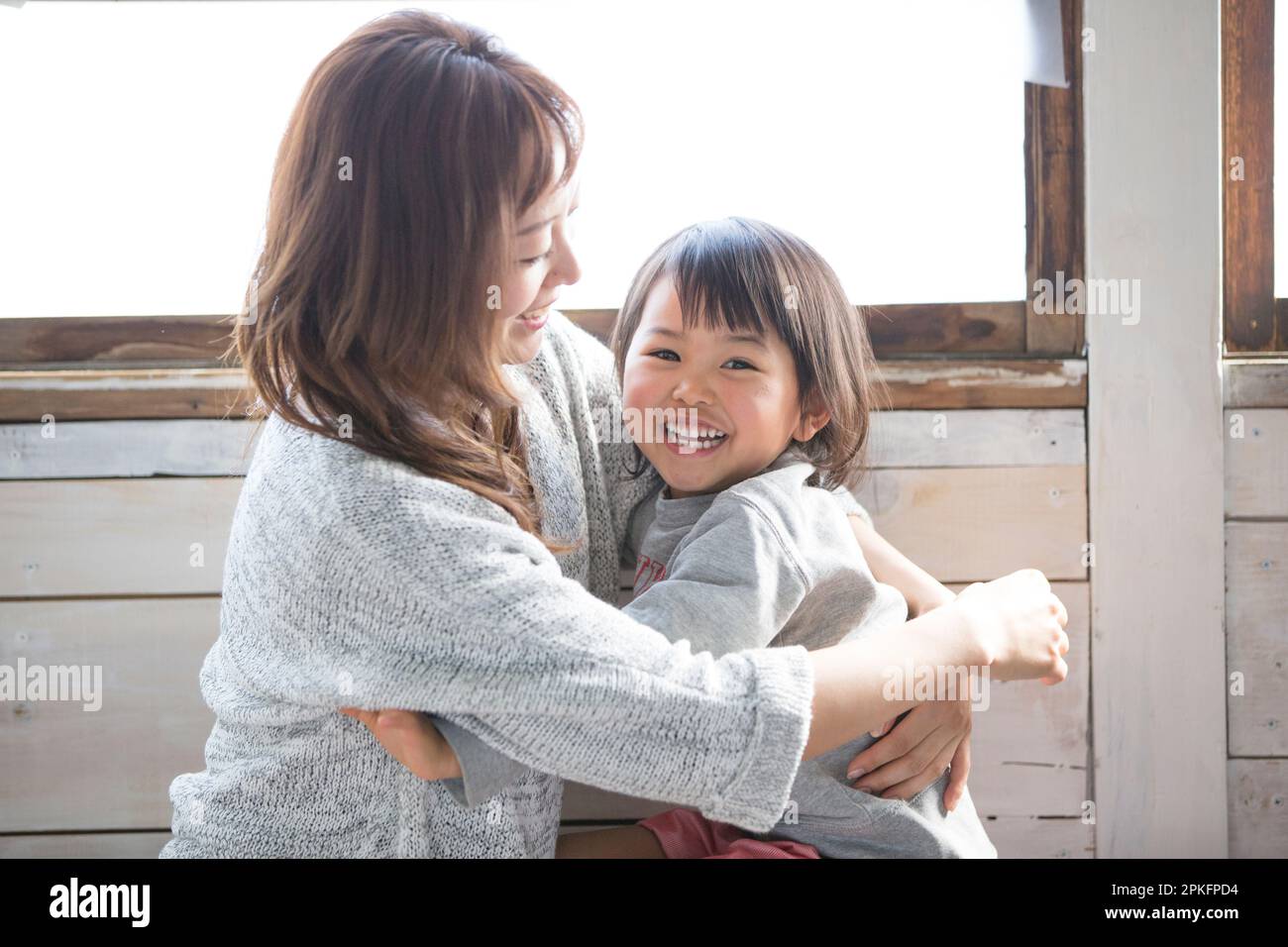 Mother and daughter hugging each other with a smile Stock Photo - Alamy