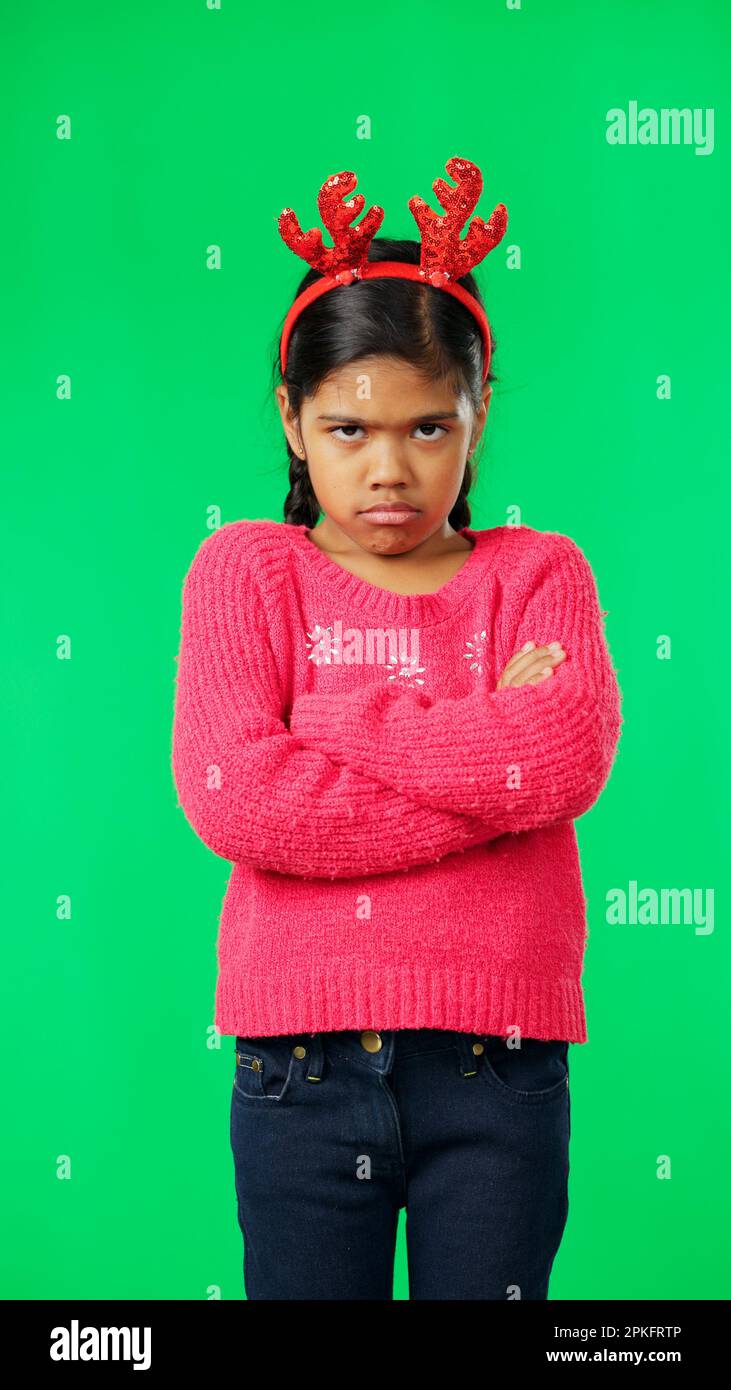 Portrait, christmas and an unhappy girl on a green screen background ...