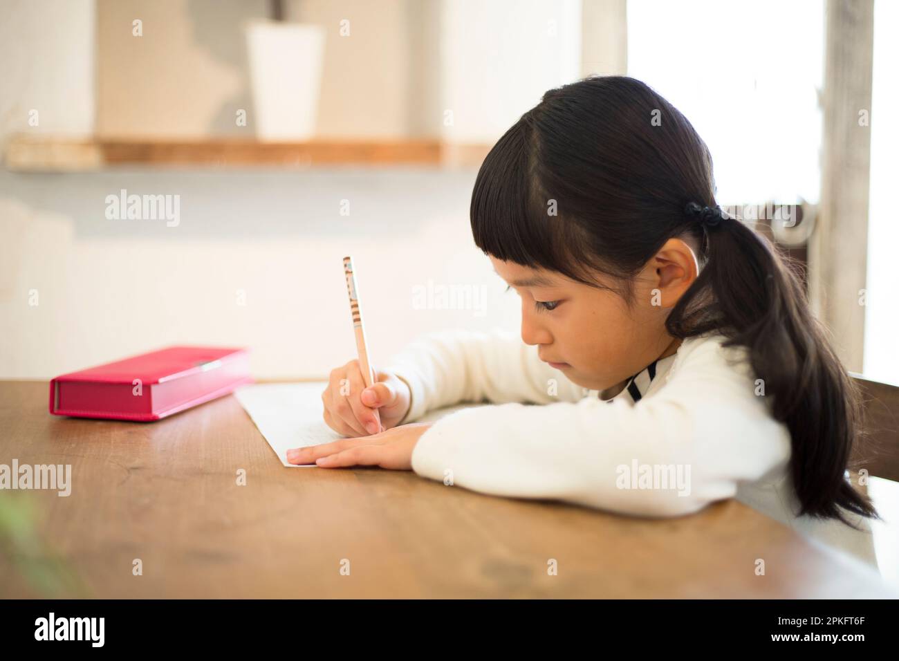 Girl studying at desk Stock Photo - Alamy