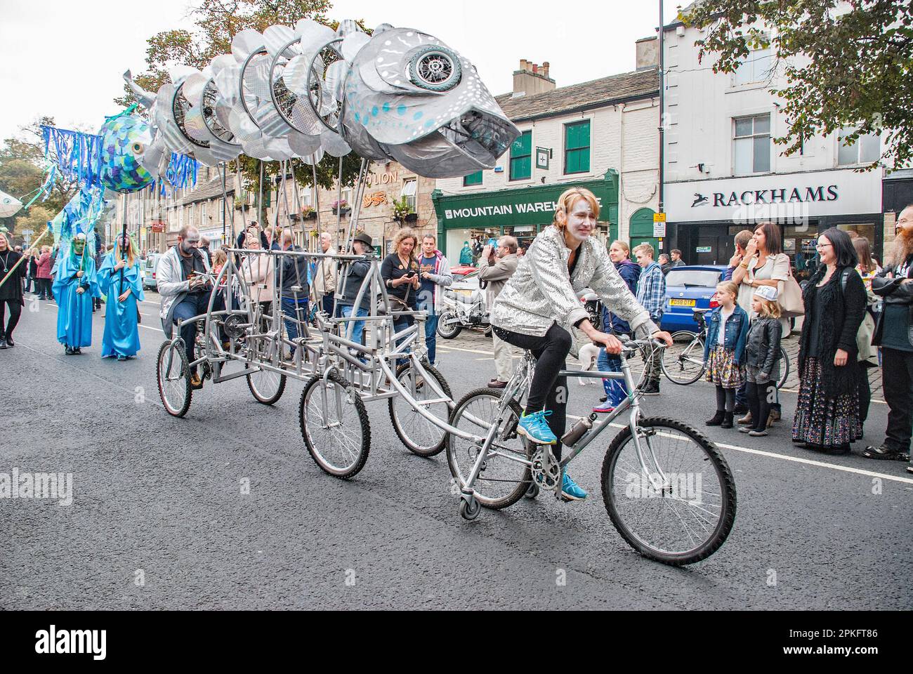 Giant fish is hauled by a cyclist in the street parade at the Skipton ...