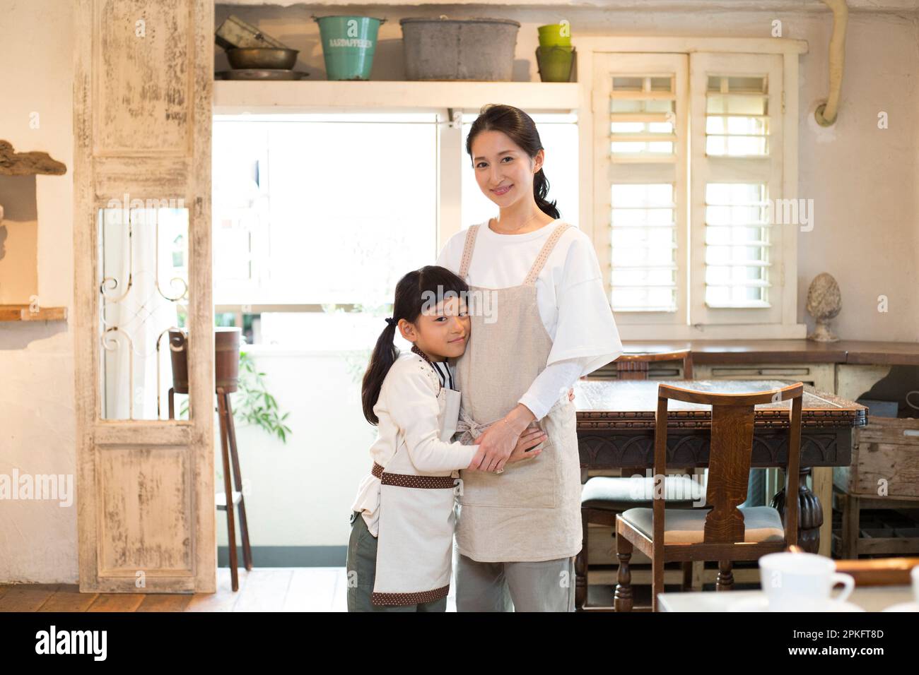 Mother and girl with apron Stock Photo - Alamy