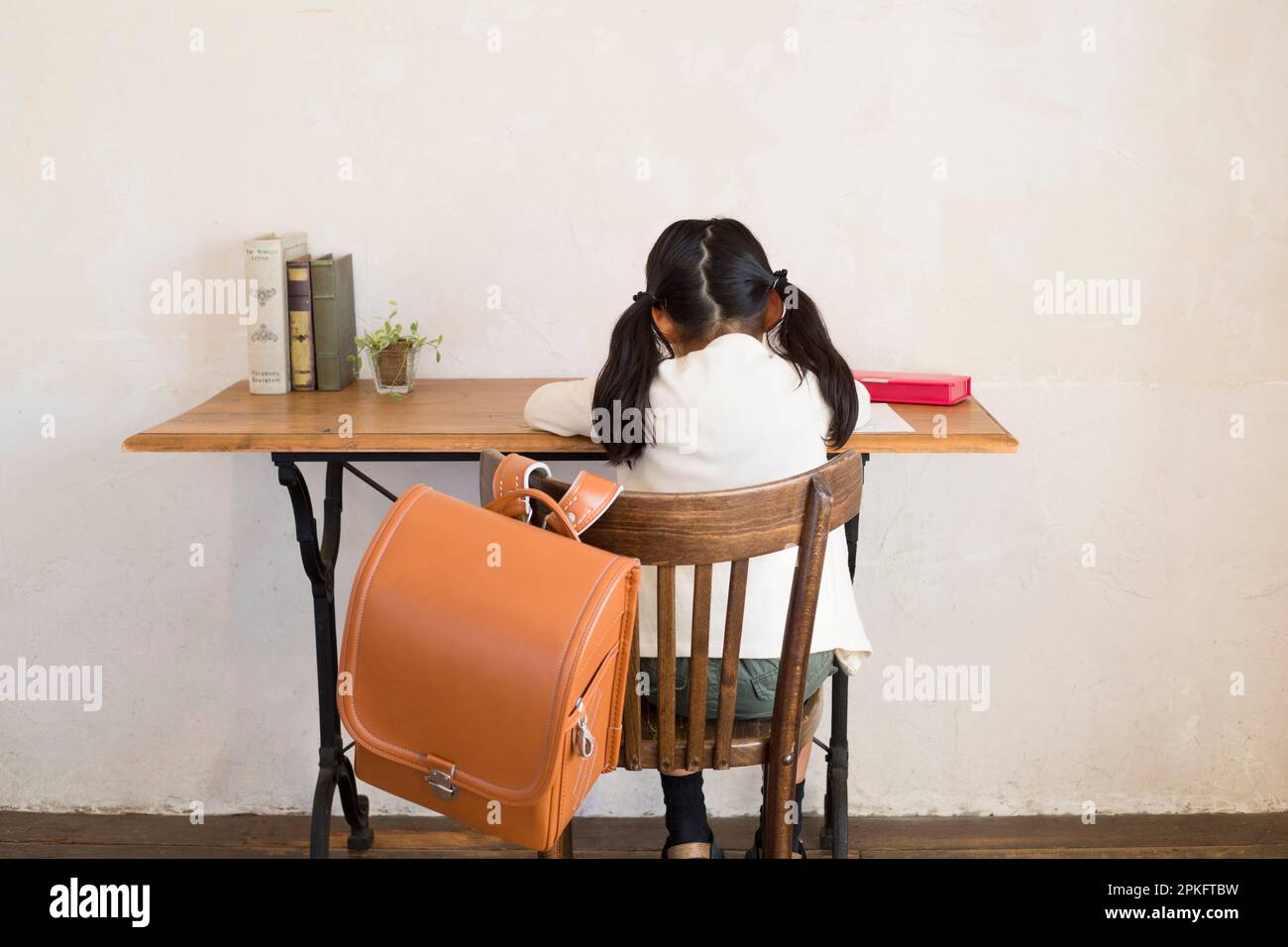 A girl sitting and studying on a chair with school backpacks Stock ...