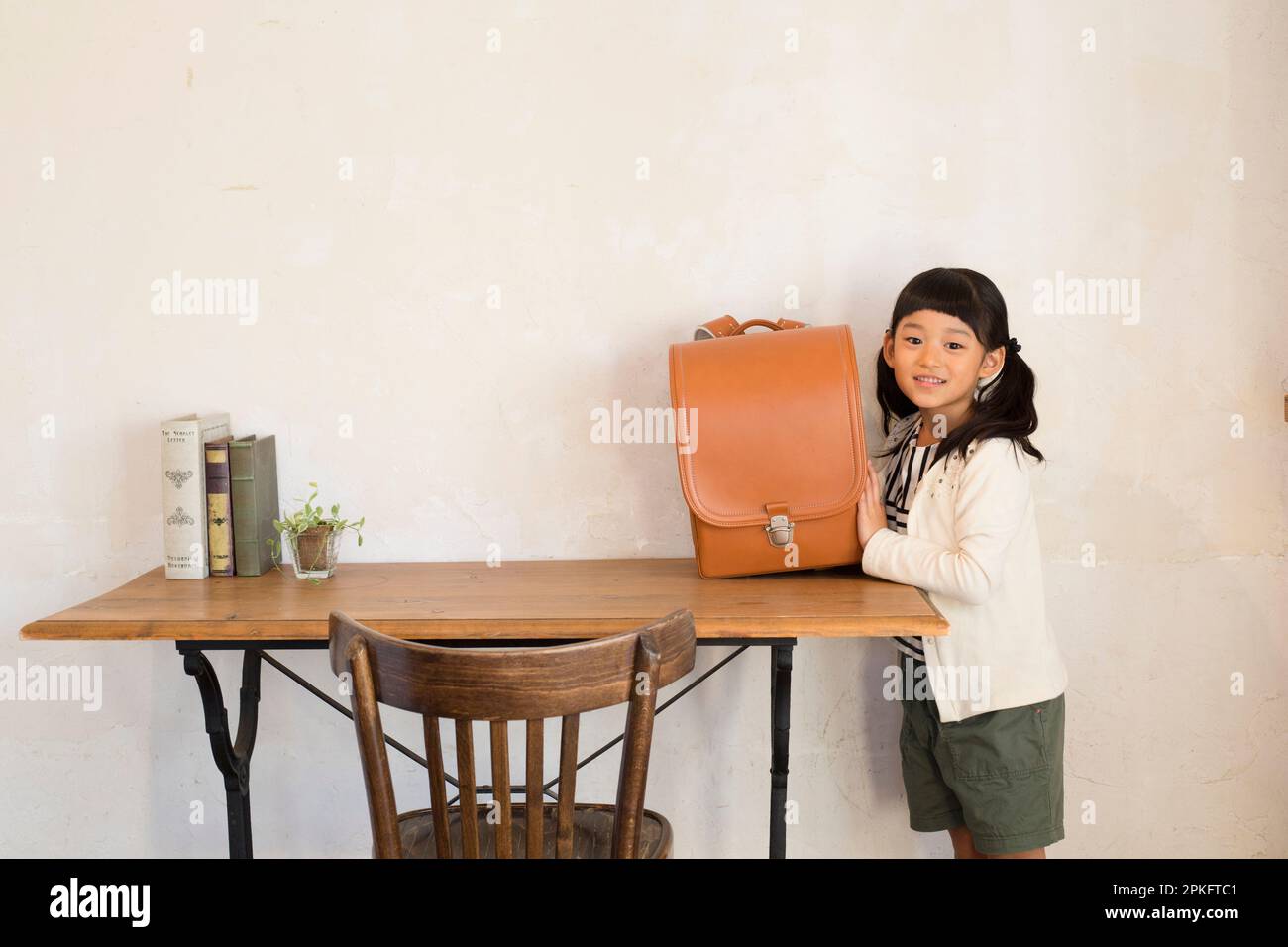 An elementary school girl with her school bag on a desk Stock Photo - Alamy