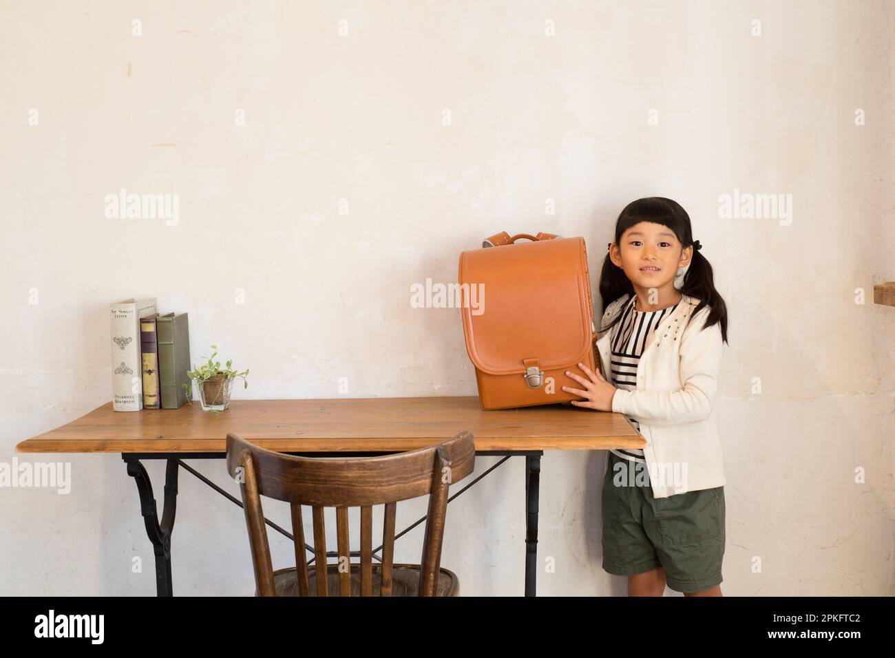 An elementary school girl with her school bag on a desk Stock Photo - Alamy