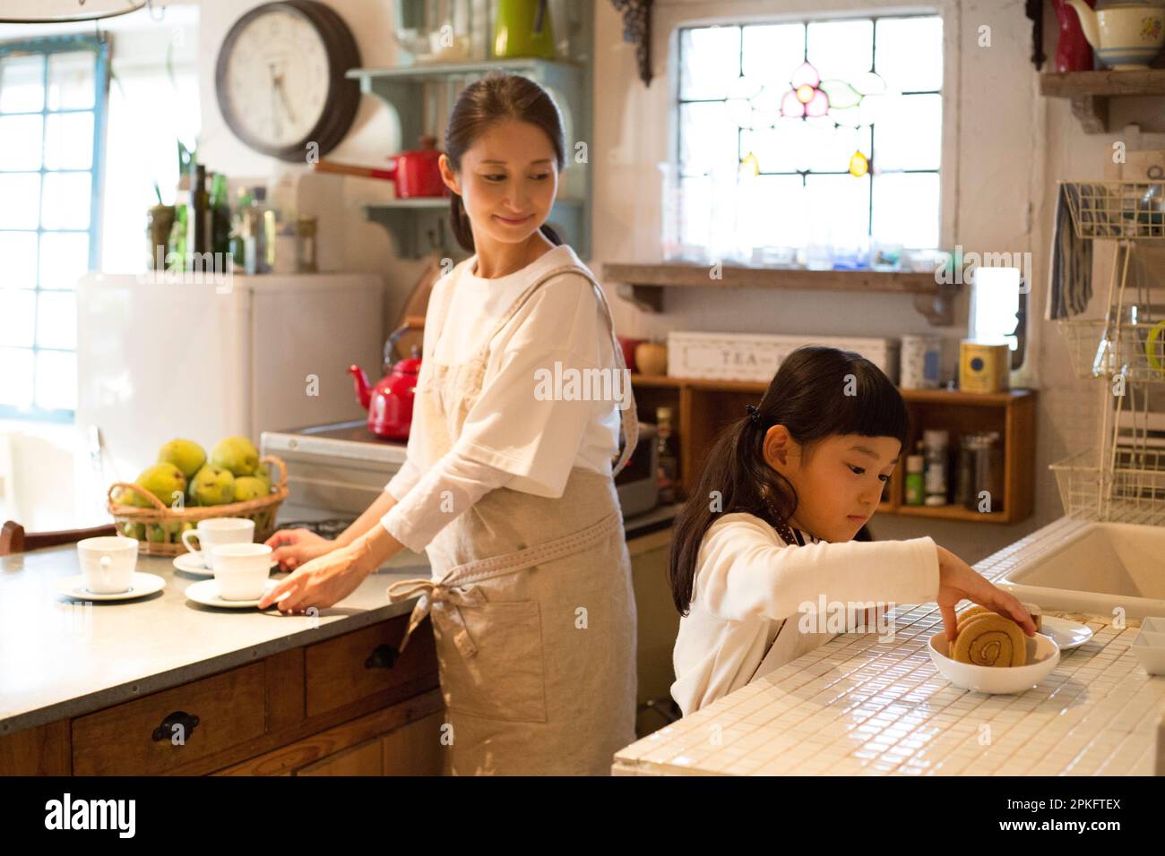 Mother and girl preparing tea and snacks in the kitchen Stock Photo - Alamy