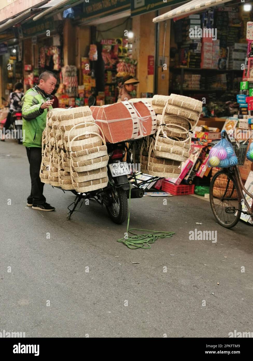 Hanoi, Vietnam. 26th Feb, 2023. A man stands next to his fully loaded ...