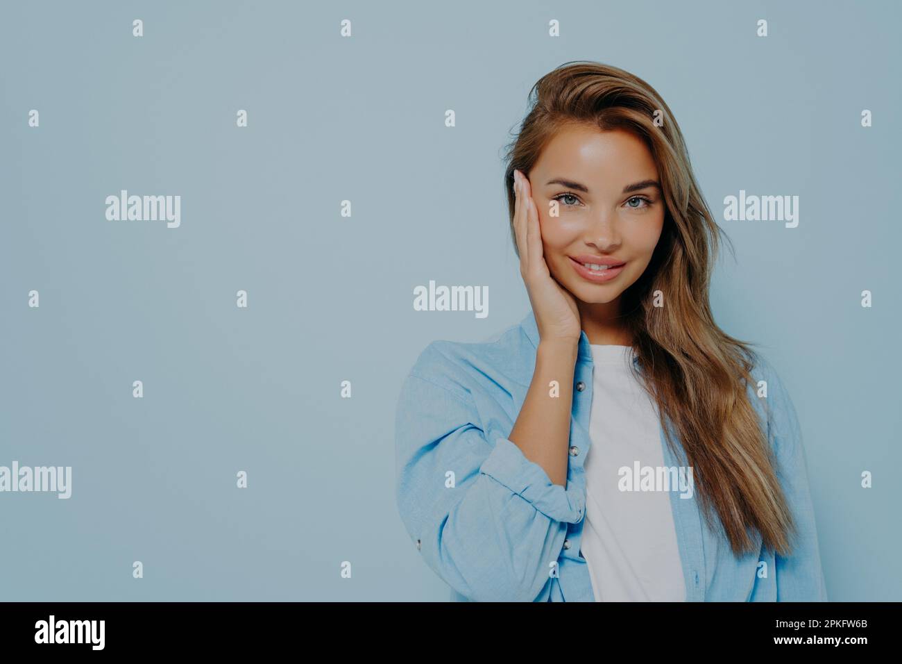Positive caucasian female looking directly at camera and smiling, being ...