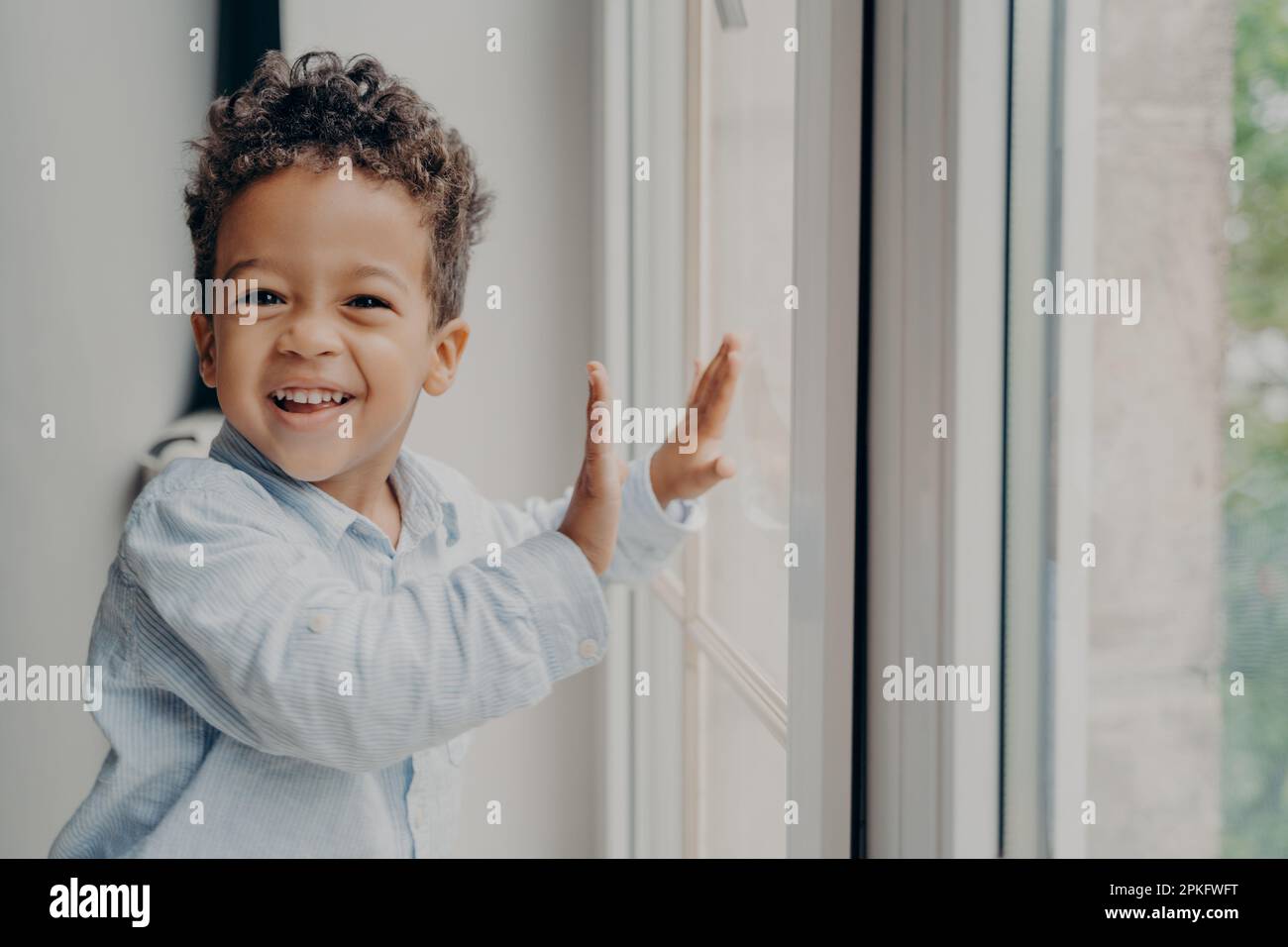Portrait of little joyful kid with adorable smile and curly hair ...