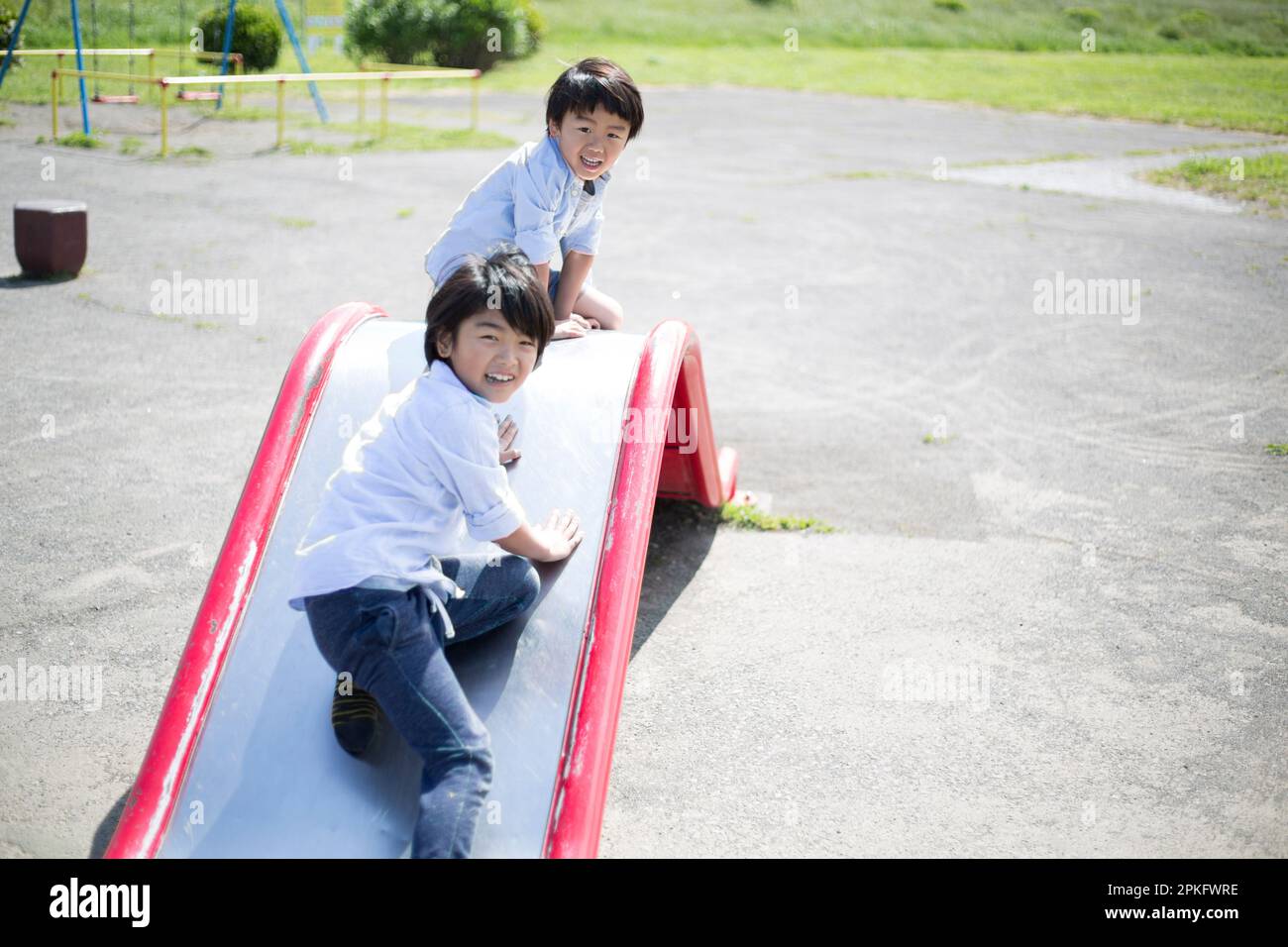 Brothers playing on playground equipment Stock Photo - Alamy