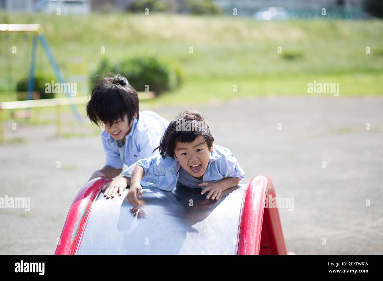 Boys playing on playground equipment Stock Photo - Alamy