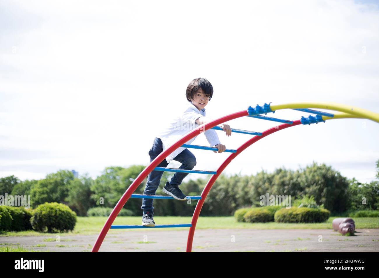 Elementary school boy playing on the playground equipment Stock Photo ...