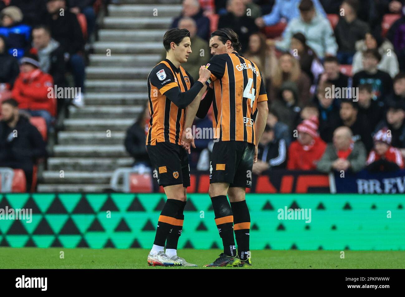 Alfie Jones #5 of Hull City puts the captains armband on Jacob Greaves ...