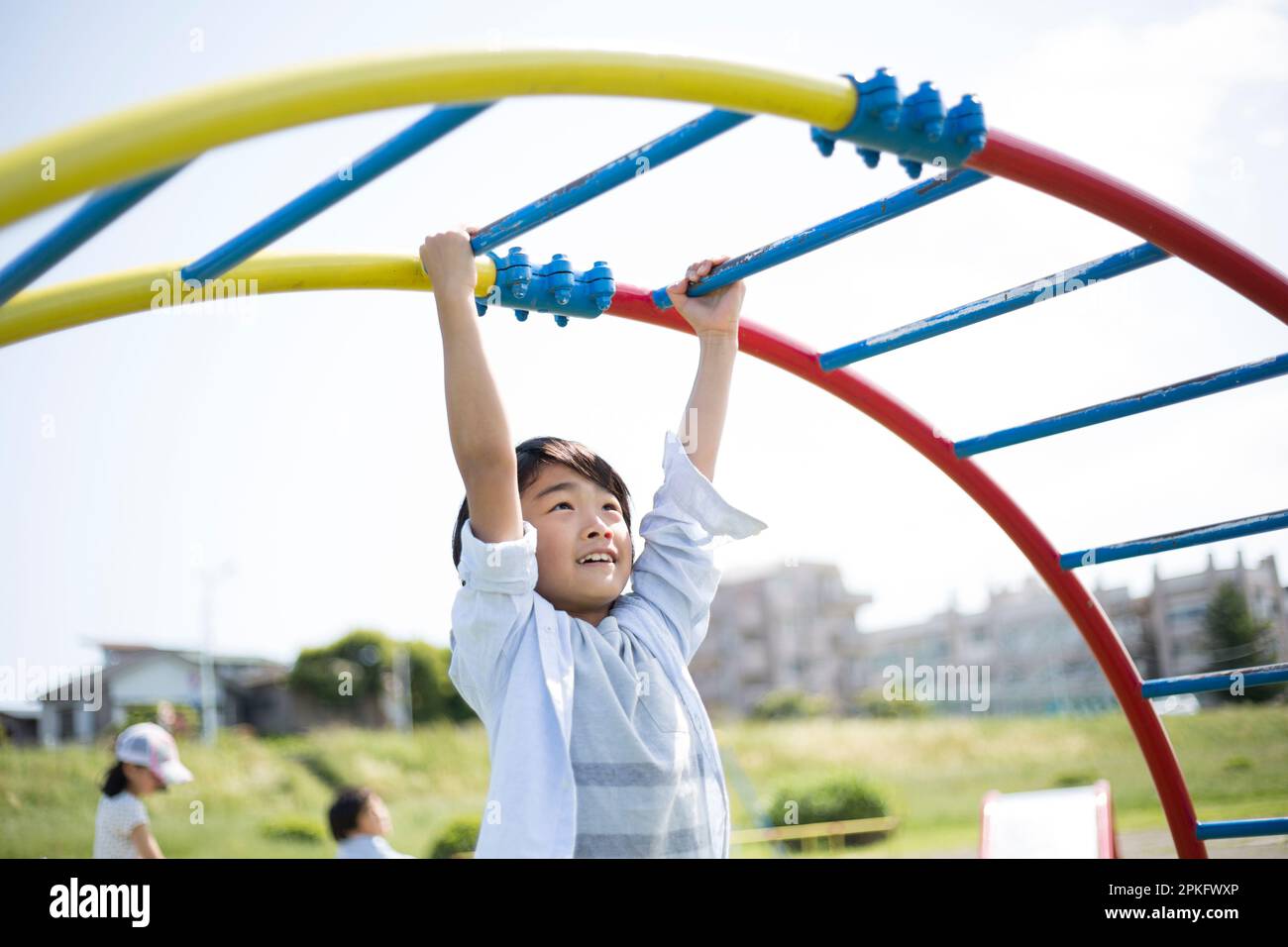 Elementary school boy playing on the playground equipment at the park ...