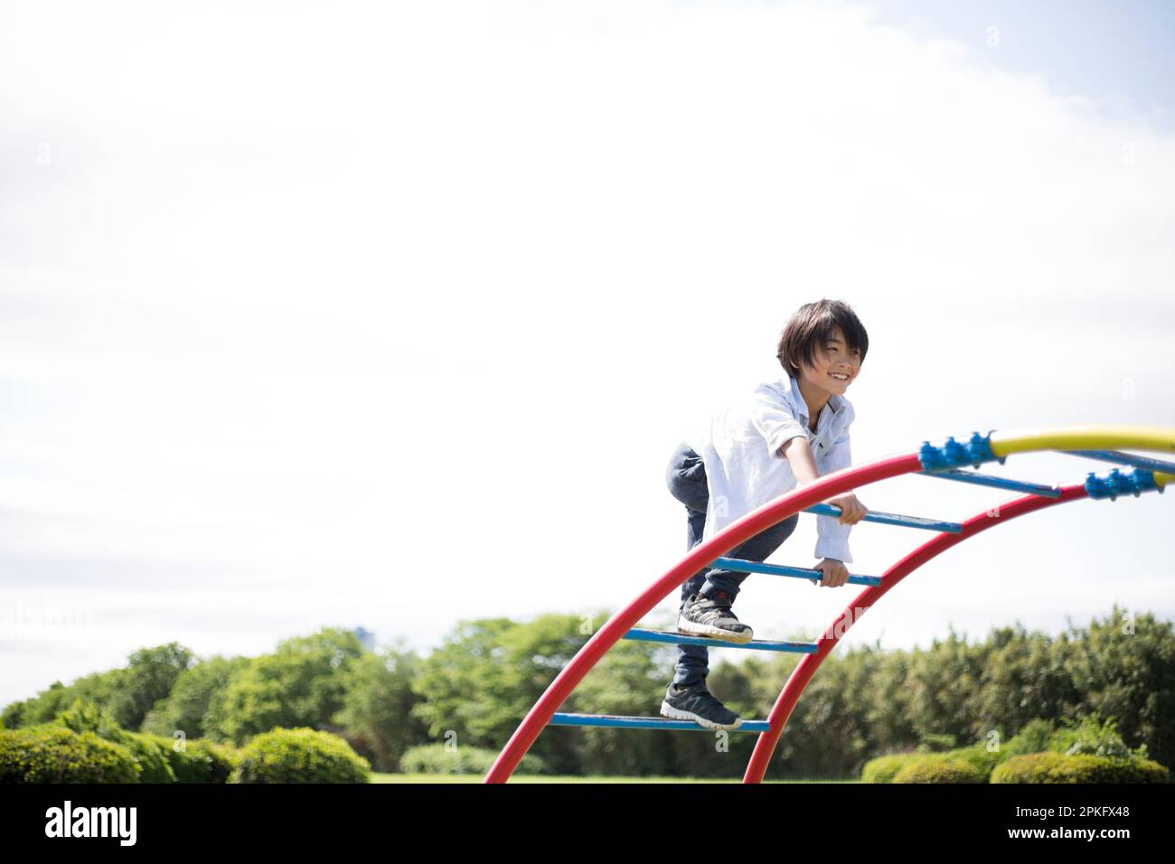 Elementary school boy playing on the playground equipment Stock Photo ...