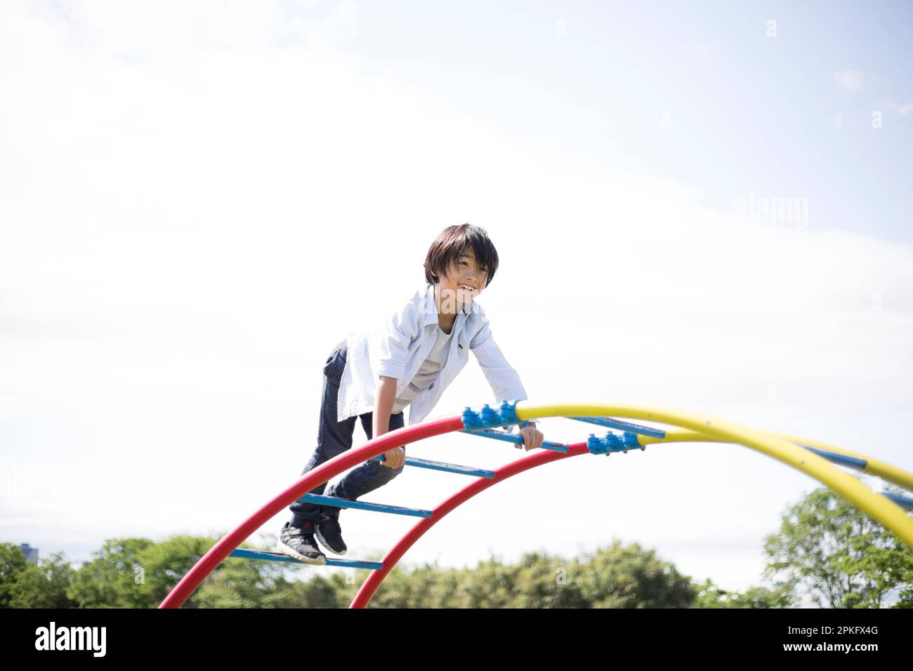 Elementary school boy playing on the playground equipment Stock Photo ...