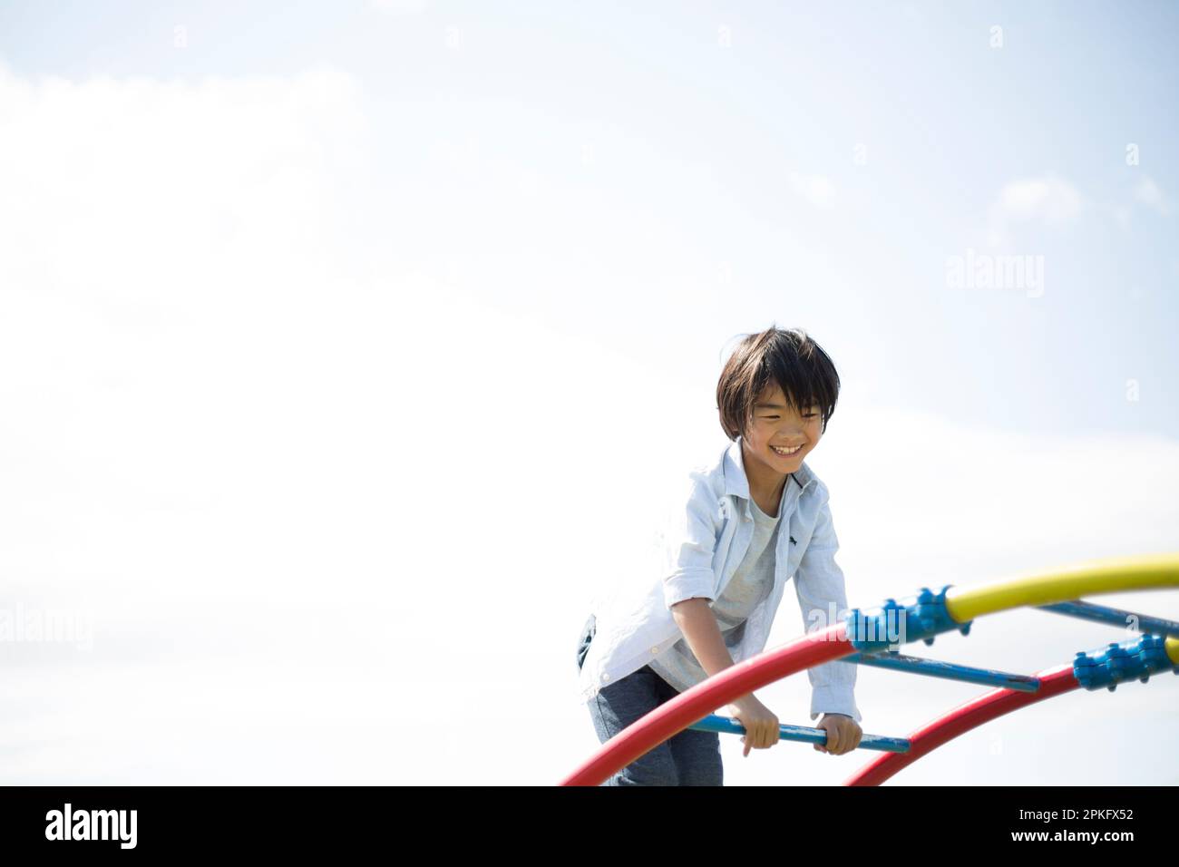 Elementary school boy playing on the playground equipment at the park ...