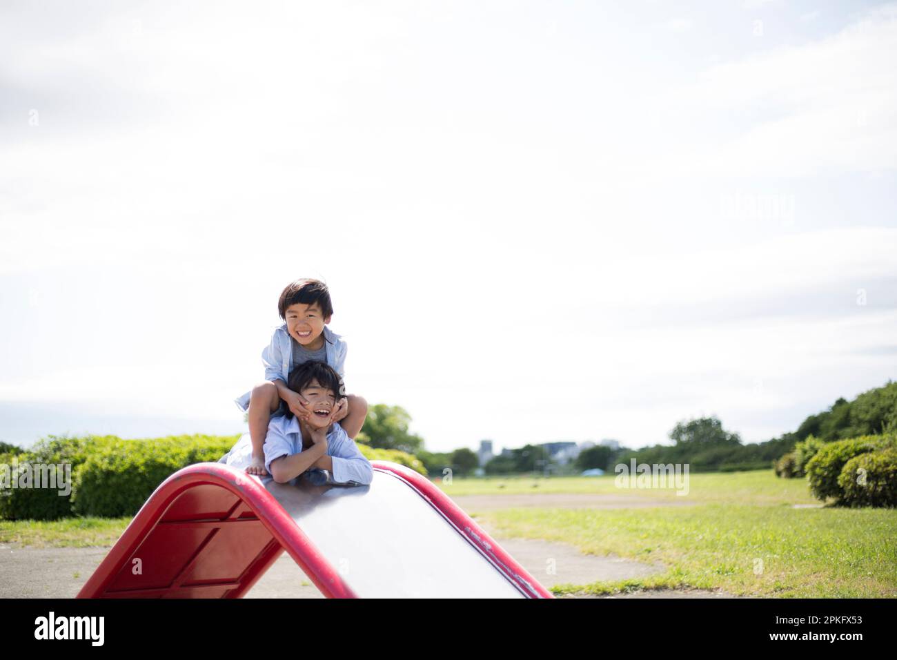 Boys playing on the slide at the park Stock Photo - Alamy